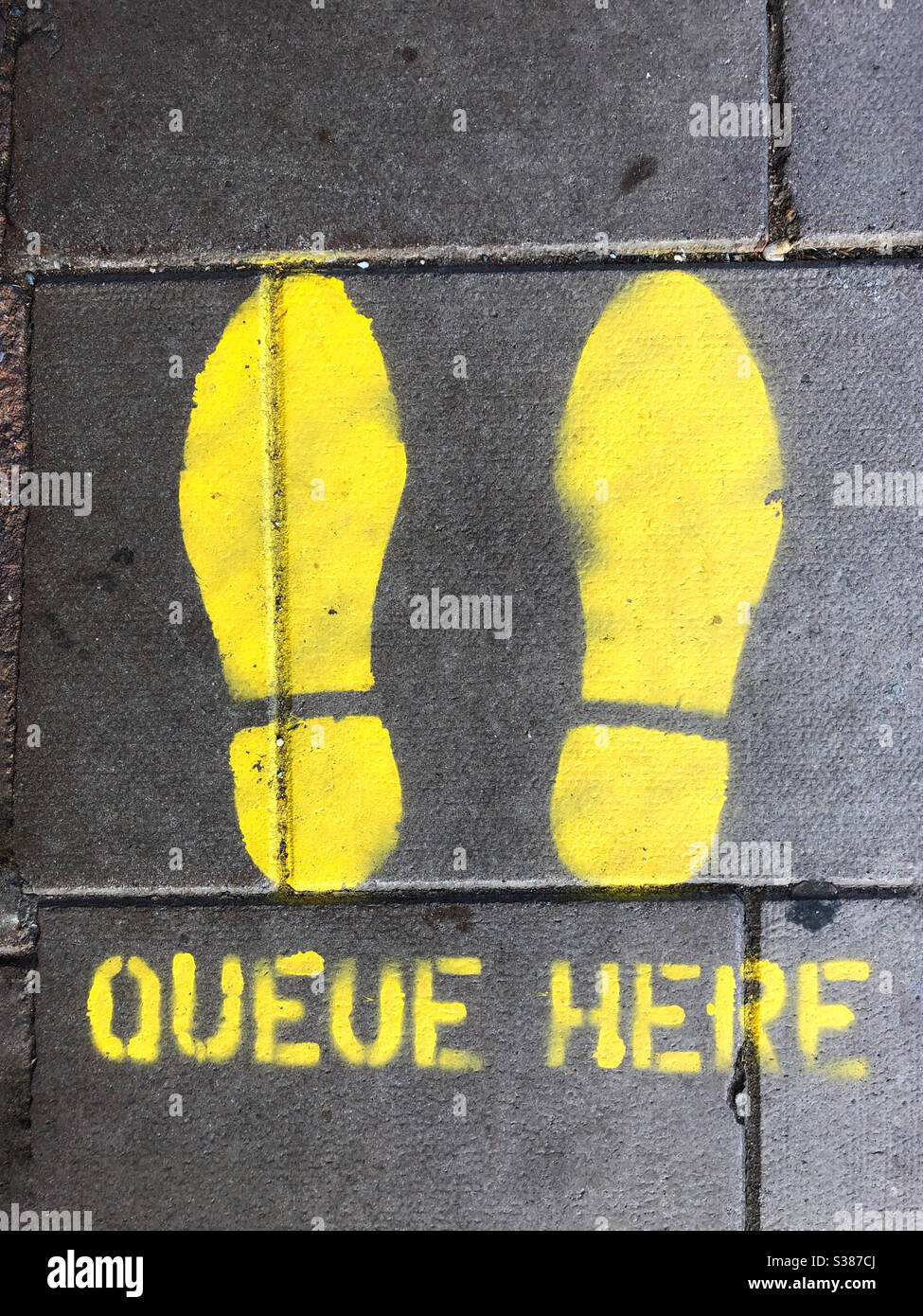 Queue Here sign for social distancing outside a shop UK Stock Photo - Alamy