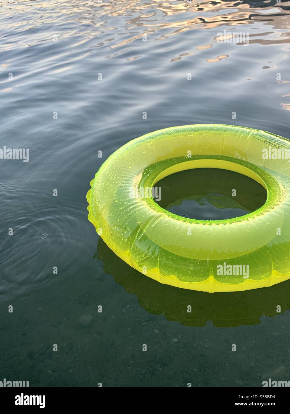 Swimming ring floating on calm lake water Stock Photo - Alamy