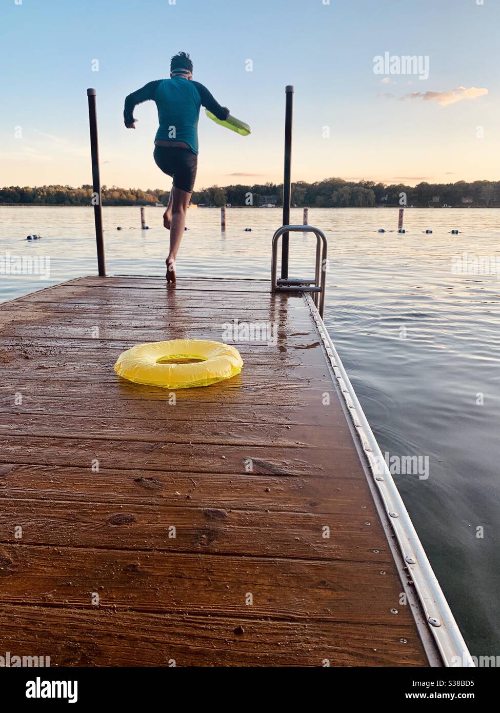 A person jumping off a dock Stock Photo - Alamy