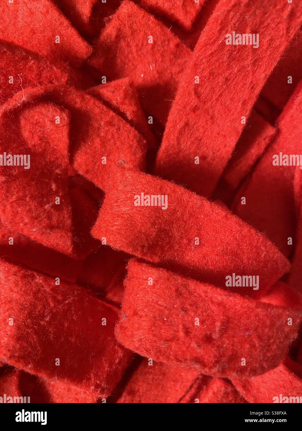 A picture of red felt pieces sitting at random angles, showing light ...