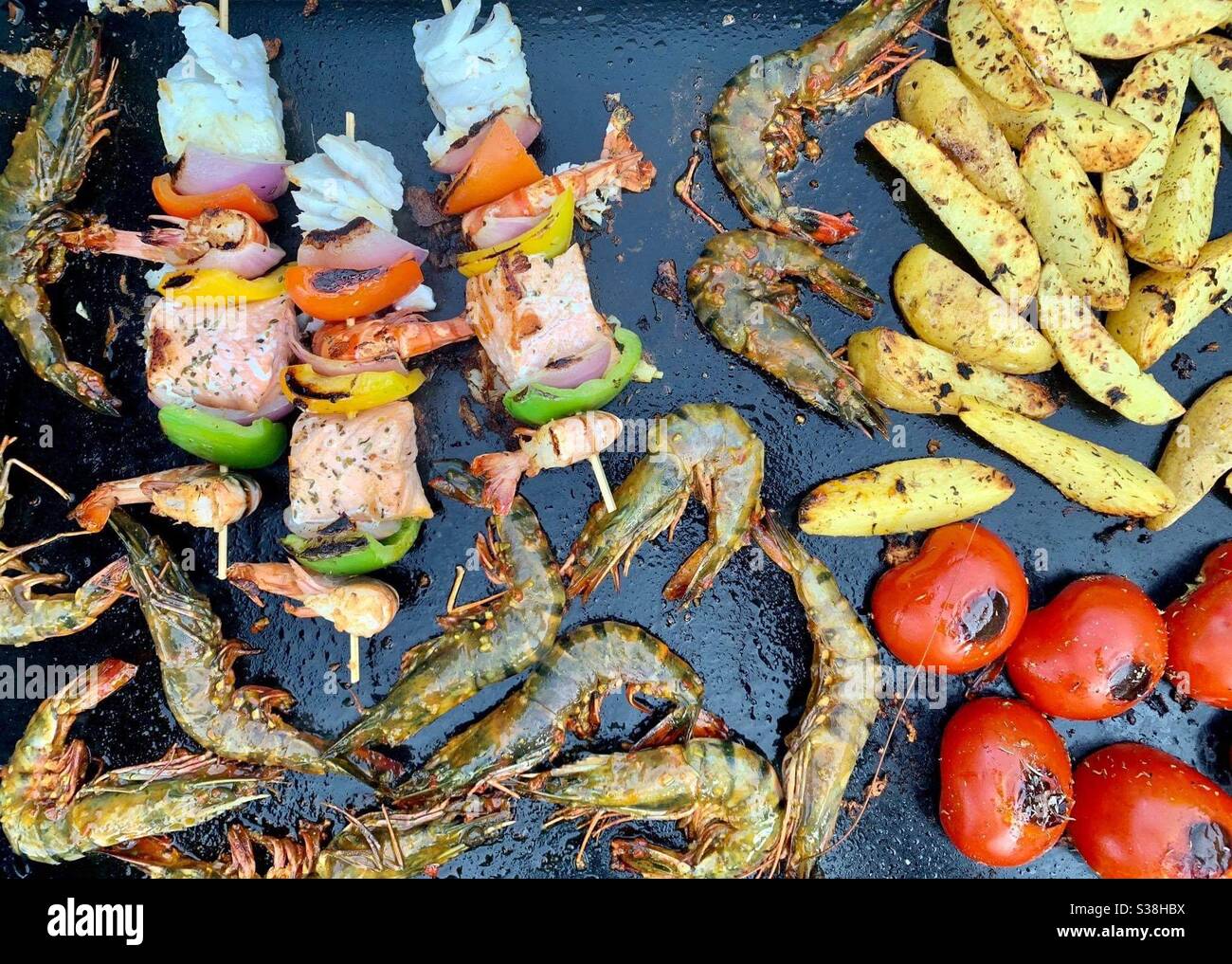 Plancha cooking with seafood, tomatoes and potatoes Stock Photo - Alamy
