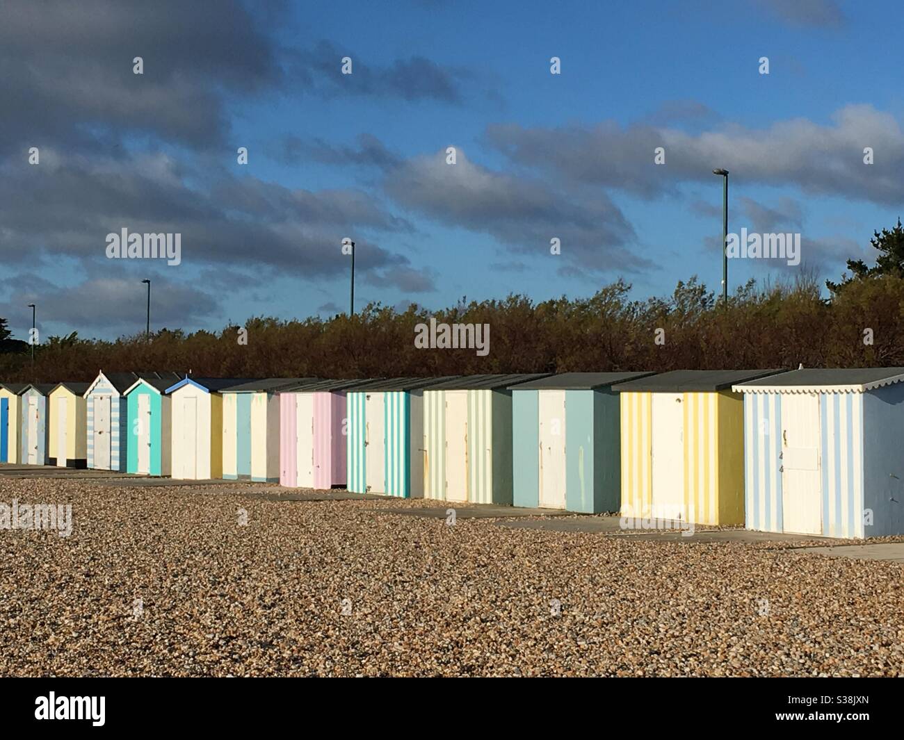 Line of multi coloured striped beach huts Stock Photo - Alamy