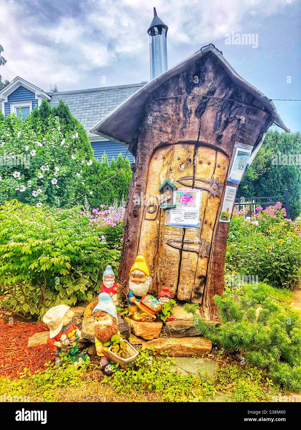 A tree trunk turned into a cute gnome home Stock Photo - Alamy