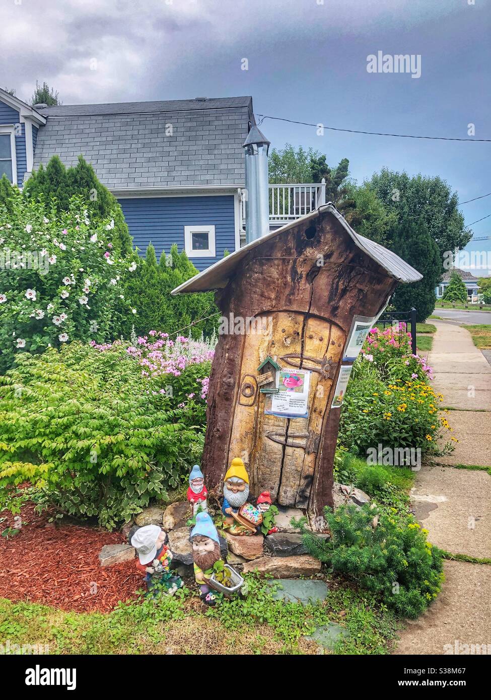 A carved out tree trunk becomes a whimsical home for garden gnomes ...