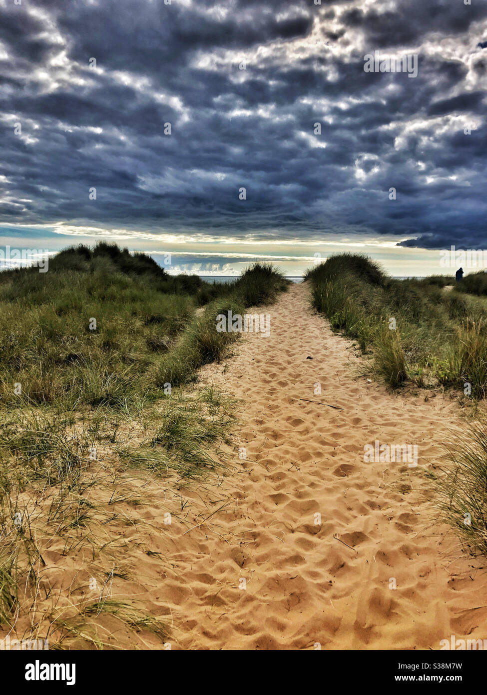 Pathway through sand dunes to the sea with a heavy brooding sky Stock ...