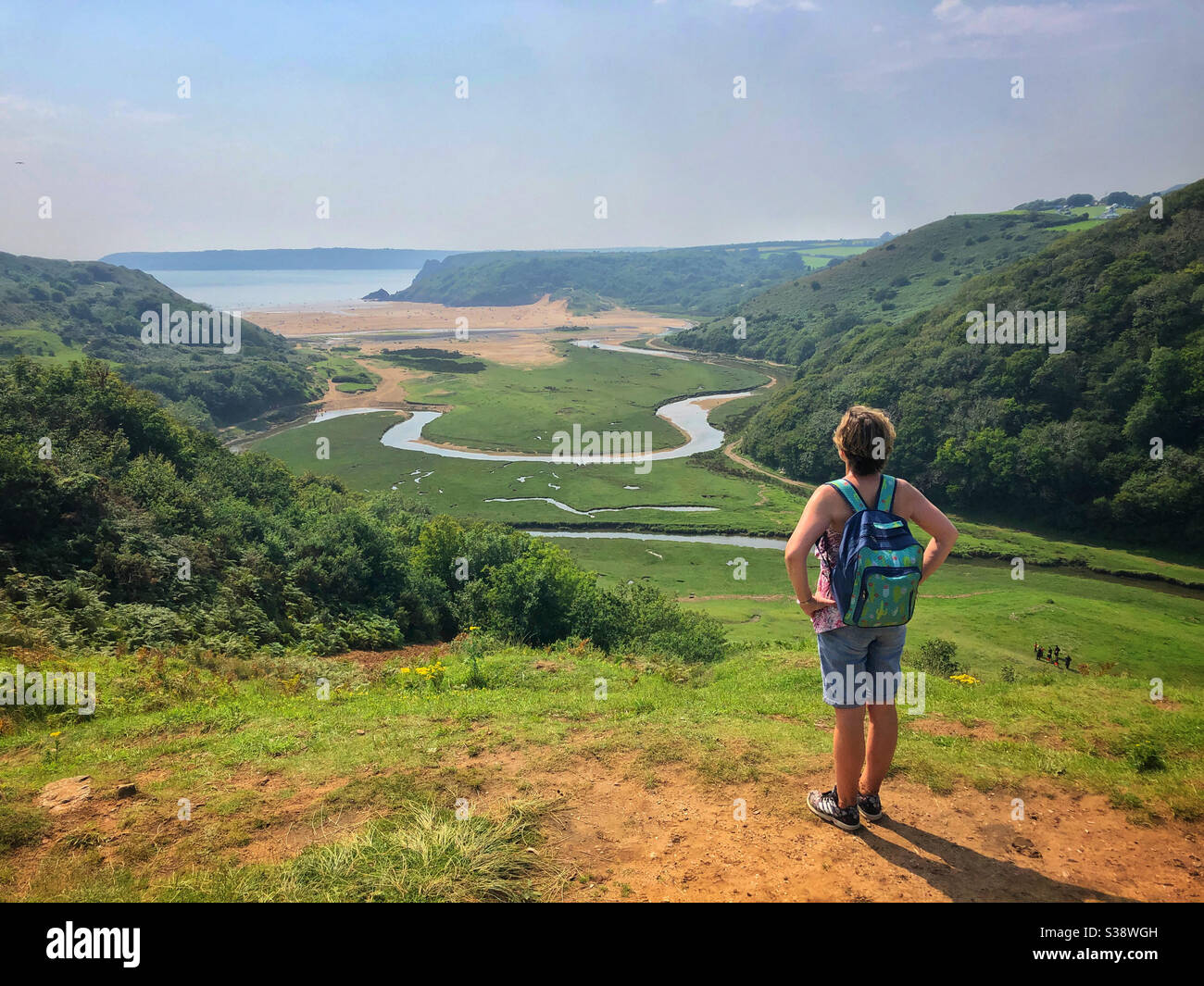 Middle aged woman enjoying the view over Pennard Pill and Three Cliffs ...