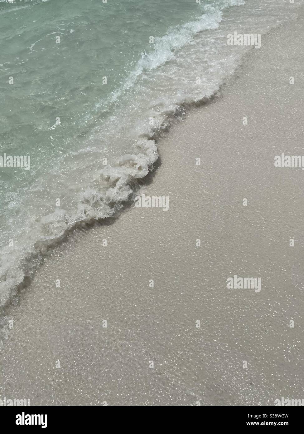 Wave hitting the shoreline on the beach Stock Photo - Alamy