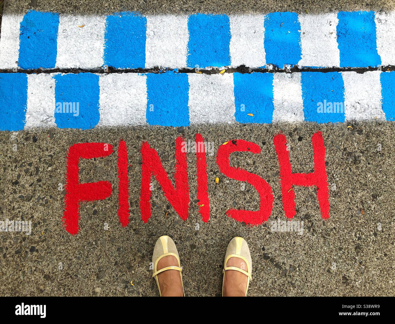 Woman standing at finish line of street race Stock Photo - Alamy