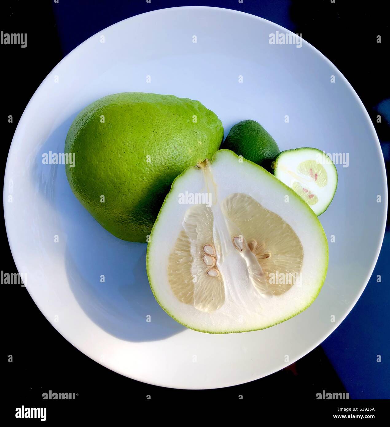 A plate of 2 sizes of Pomelo fruit sliced open, an ancestor to the grapefruit native to ...