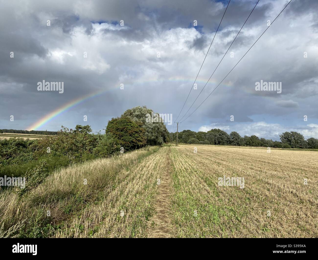 Rainbow over field Stock Photo - Alamy