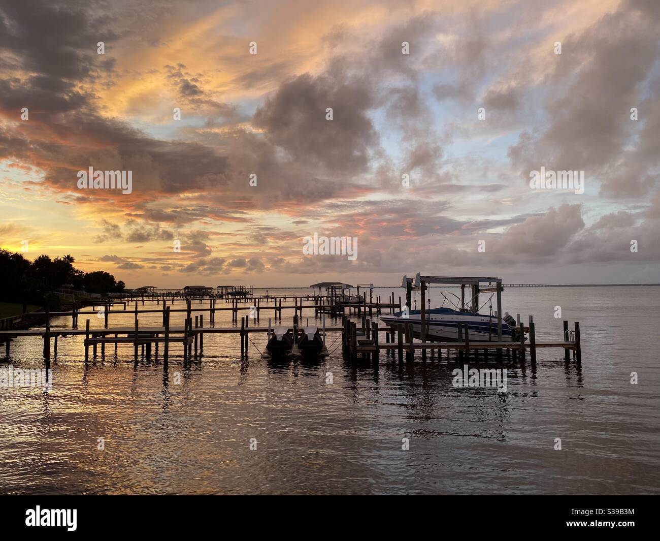 Dramatic sunset skies over bay water with boat dock and piers Stock ...
