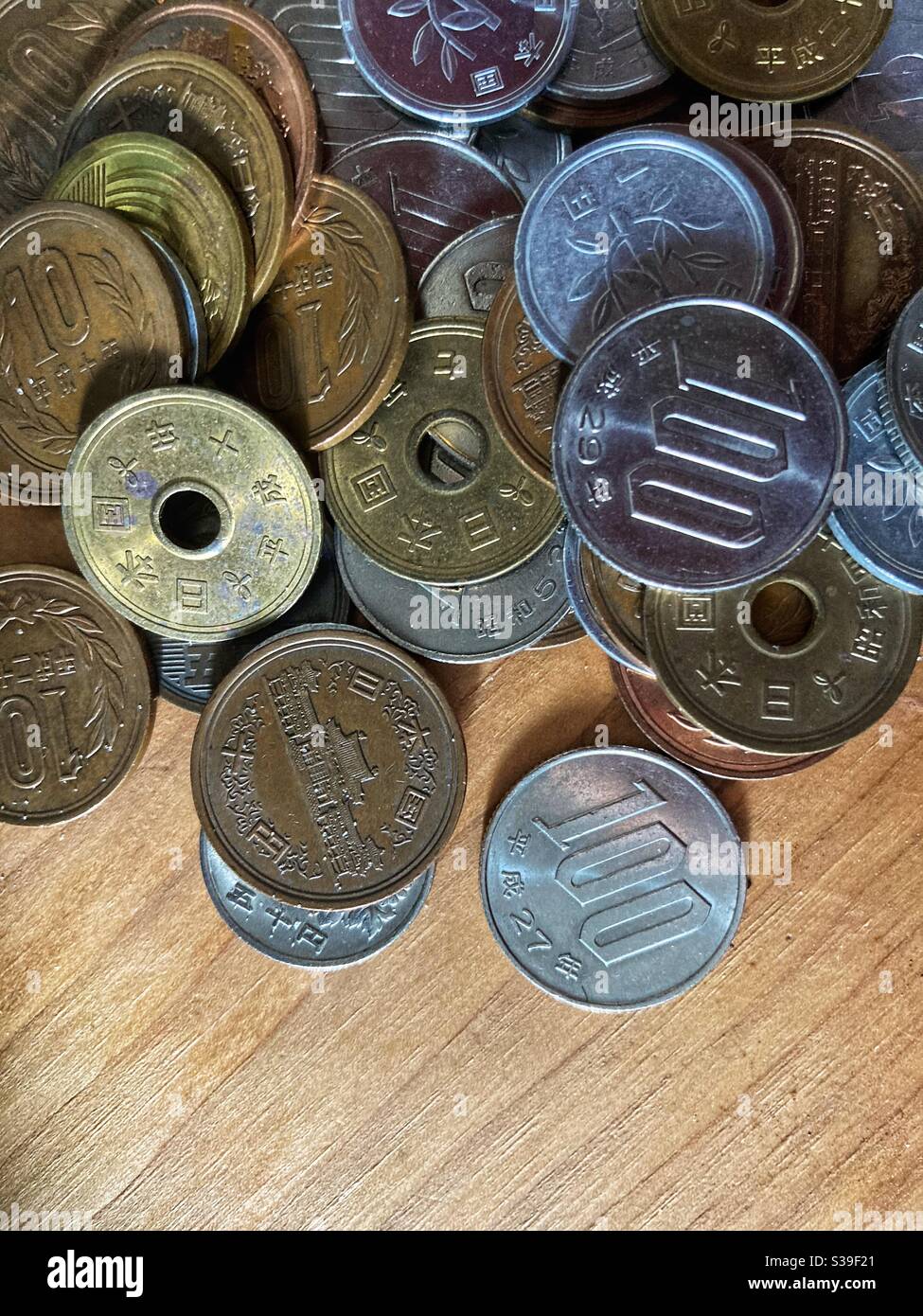 A pile of Japanese coins on a wooden surface Stock Photo - Alamy