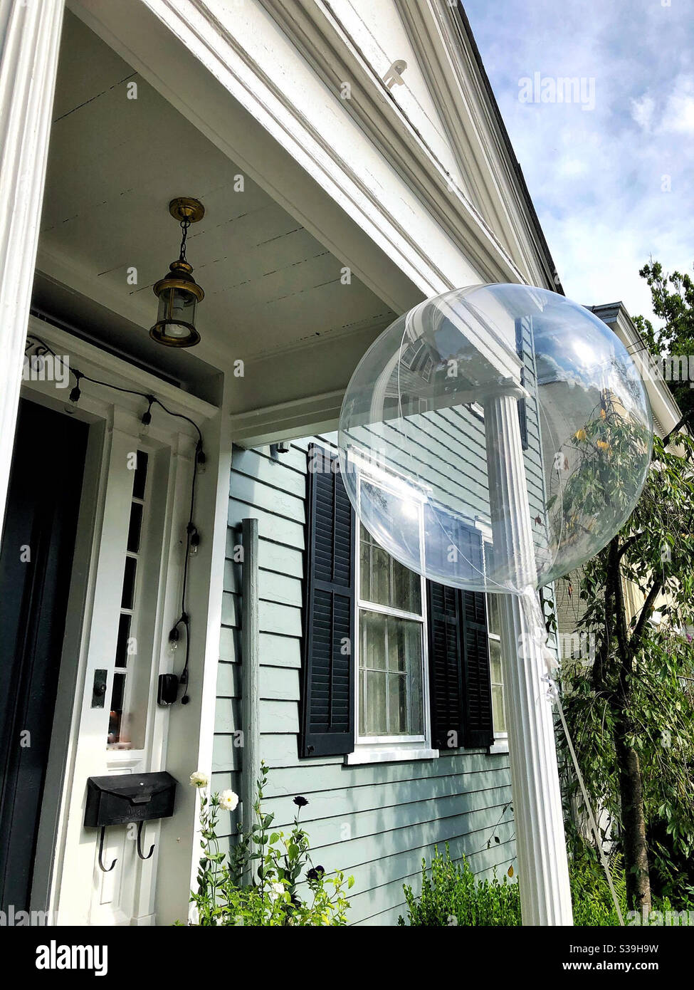 Clear round balloon welcomes guests to party Stock Photo - Alamy