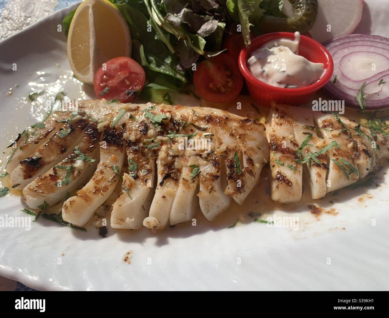 Grilled calamari with garlic and salad Stock Photo - Alamy