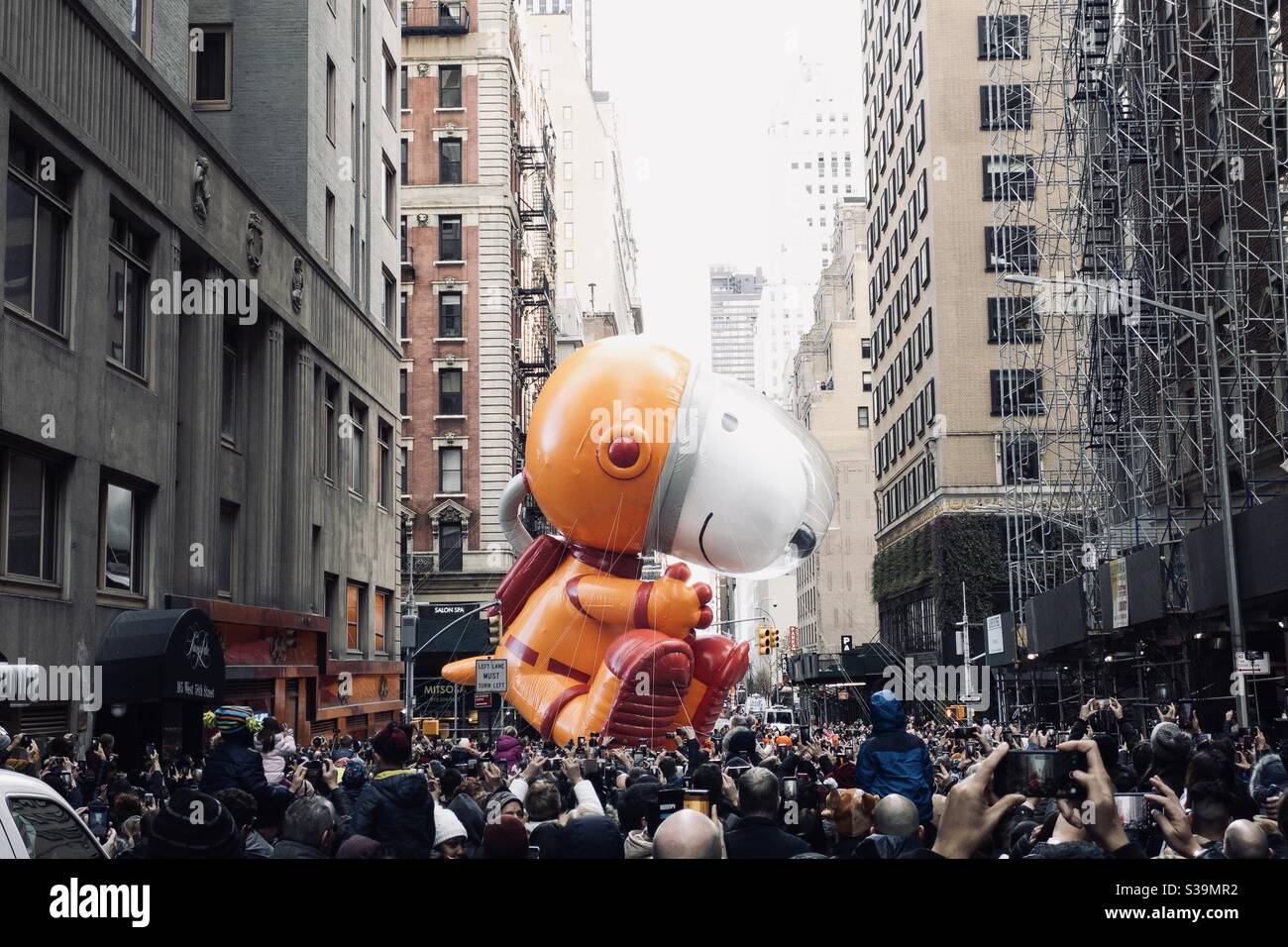 A huge Snoopy inflatable balloon is carried through the streets of New ...