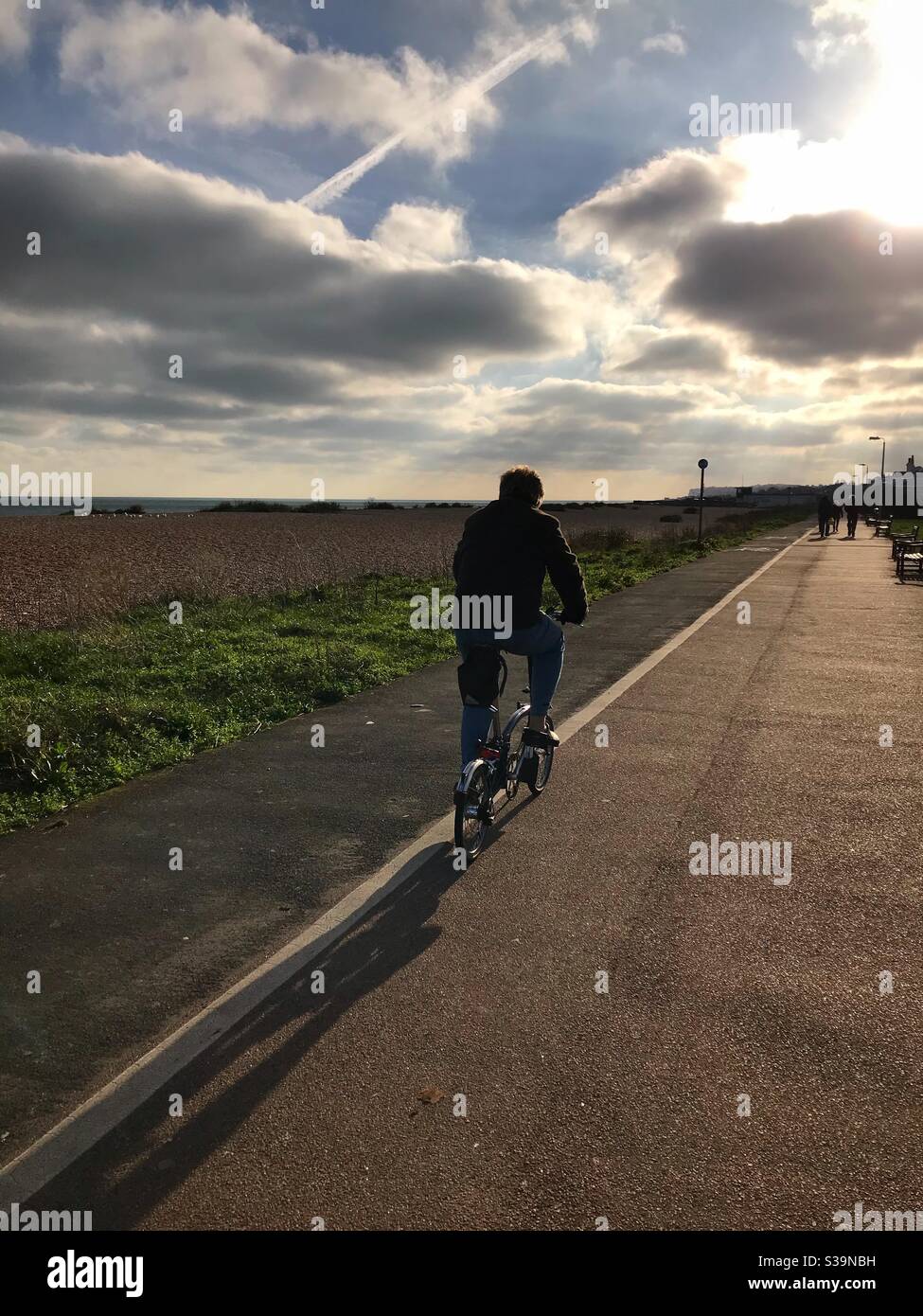 A man cycling along the promenade cycle path on his folding bike at ...