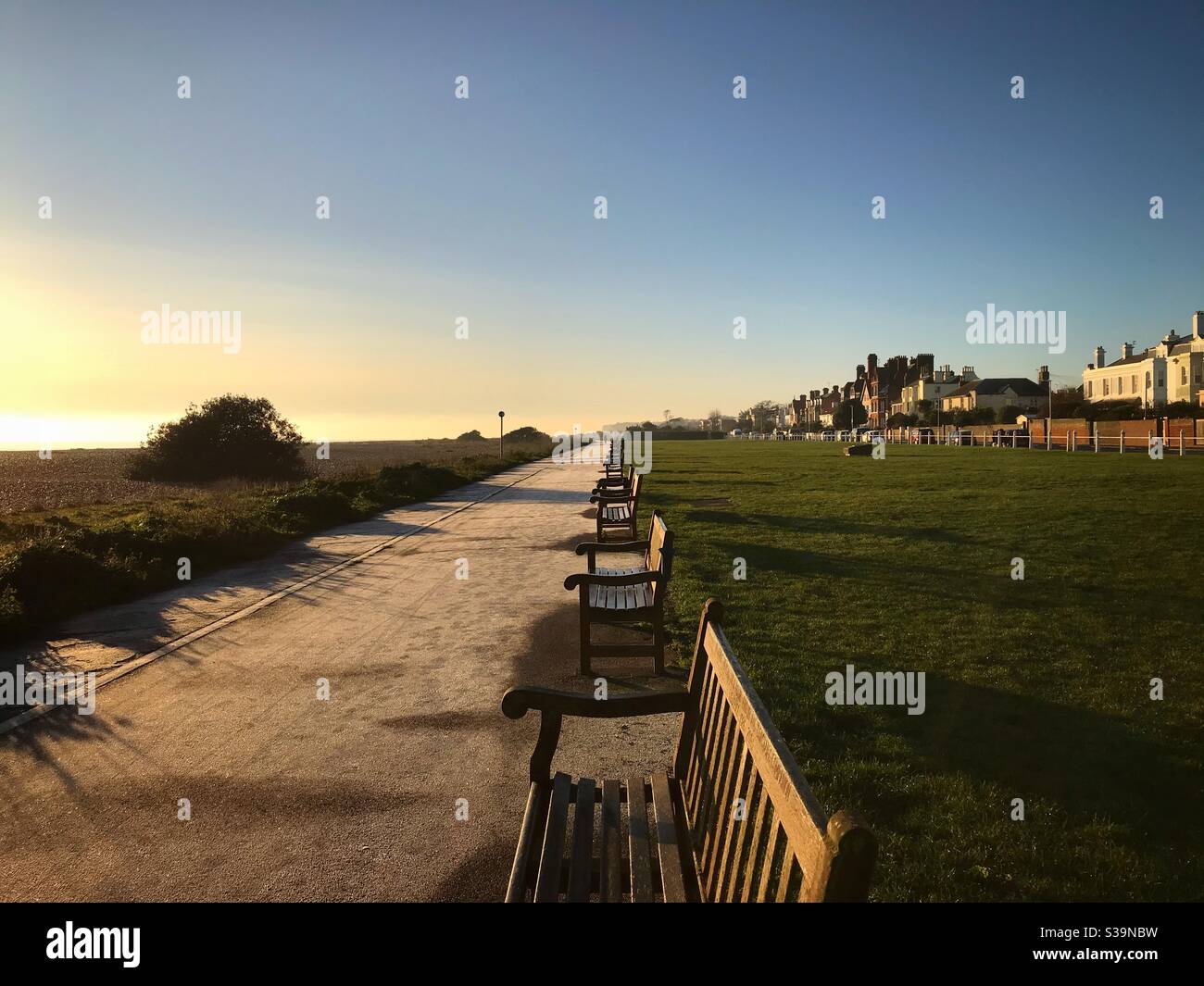 Benches in a row along the promenade beside the beach at the seaside ...