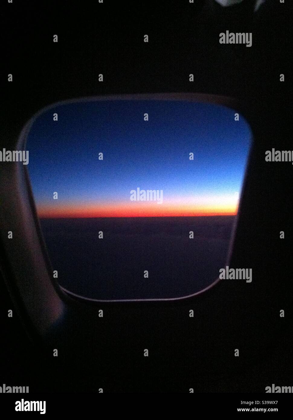 Sunrise from an airplane window Stock Photo - Alamy