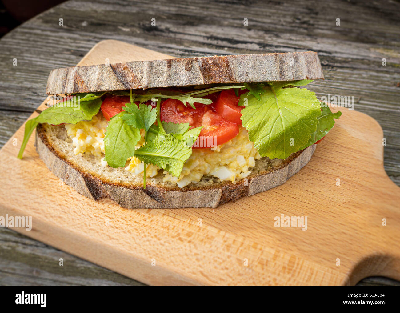Rustic egg tomato and salad sandwich with crusty sourdough bread on ...