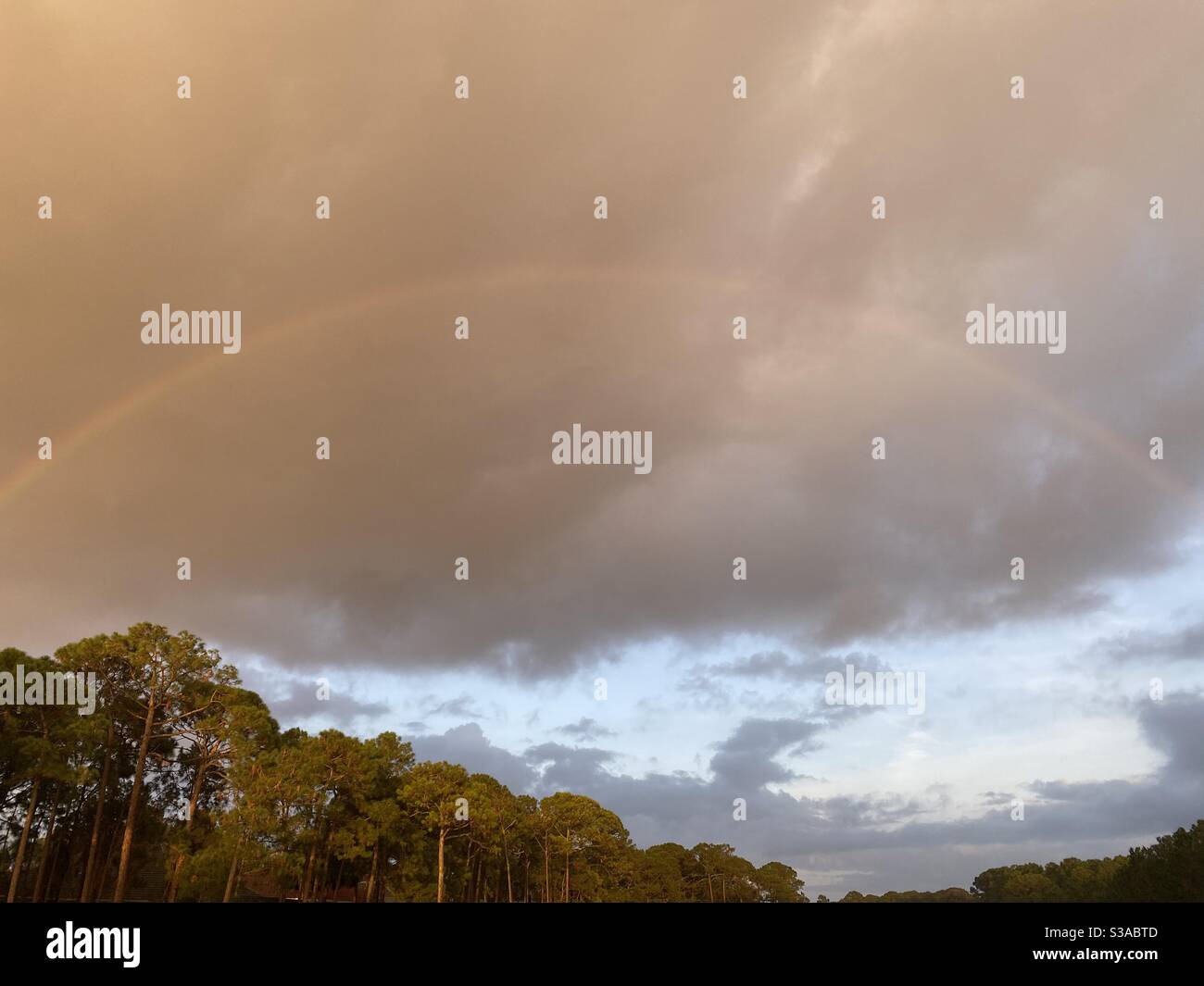 Rainbow in stormy clouds Stock Photo - Alamy