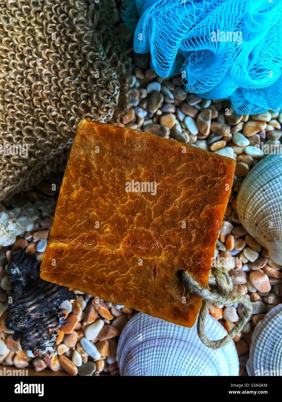 Soap cube, sponge with shells and sponge on pebbels Stock Photo - Alamy