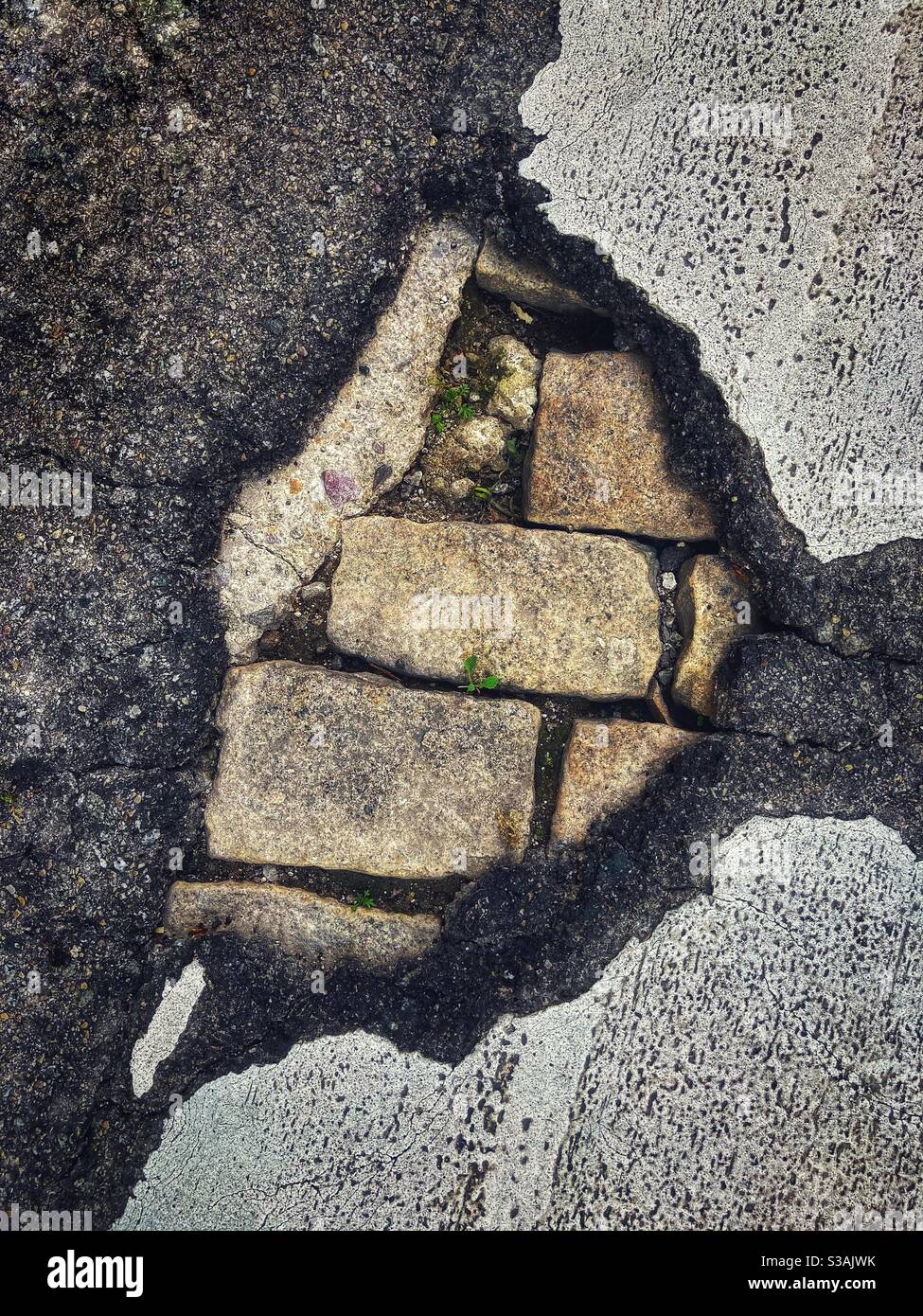 Damage pavement surface can see under cobblestone street in Spain Stock ...