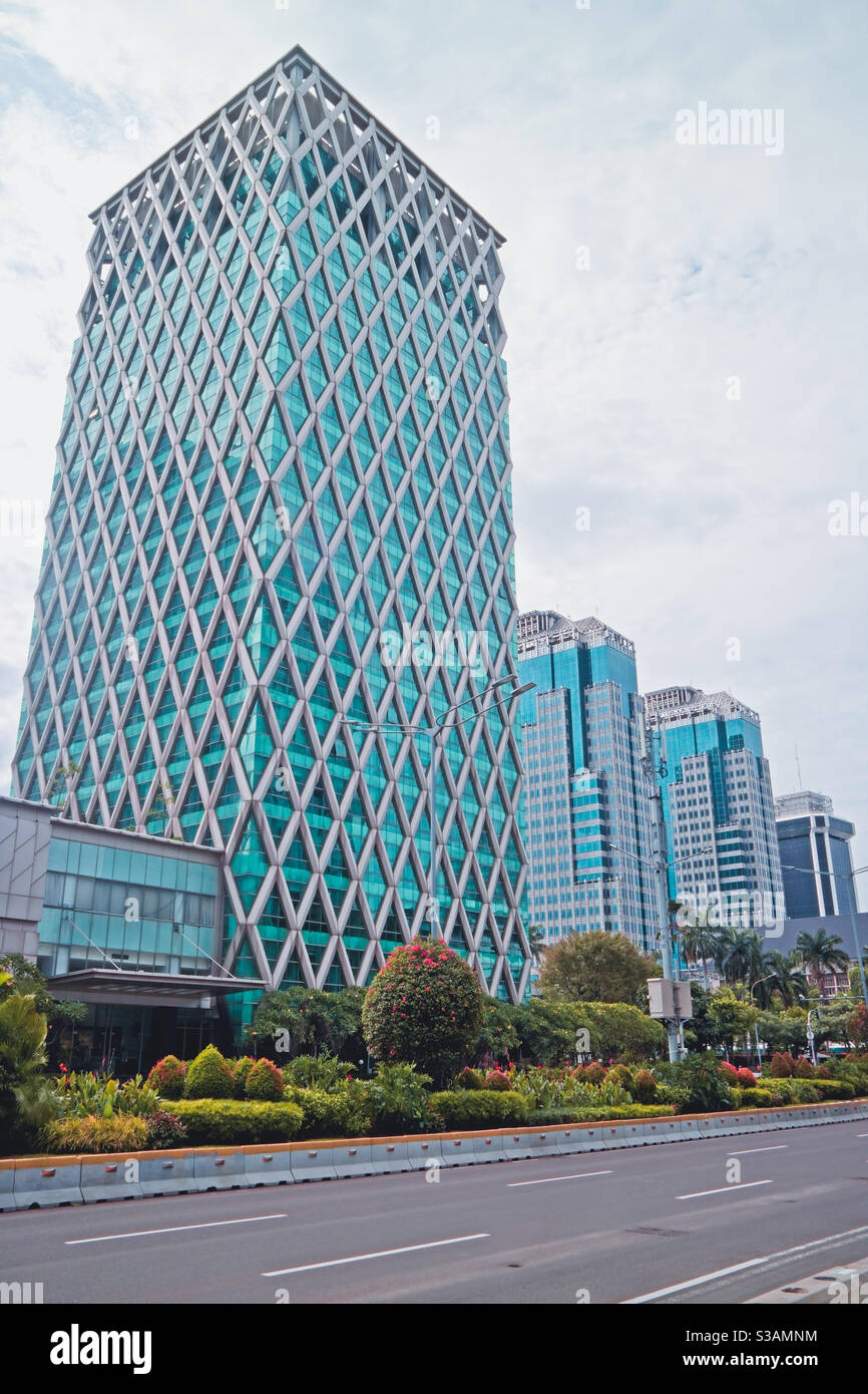 a line of tall, glass wrapped buildings on an empty street Stock Photo ...