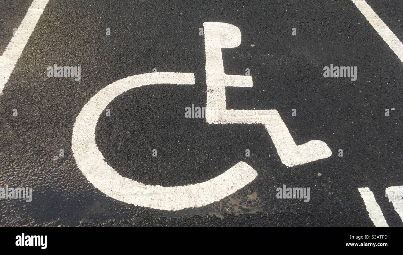 Disabled parking space on tarmac with white lines and icon of a person ...