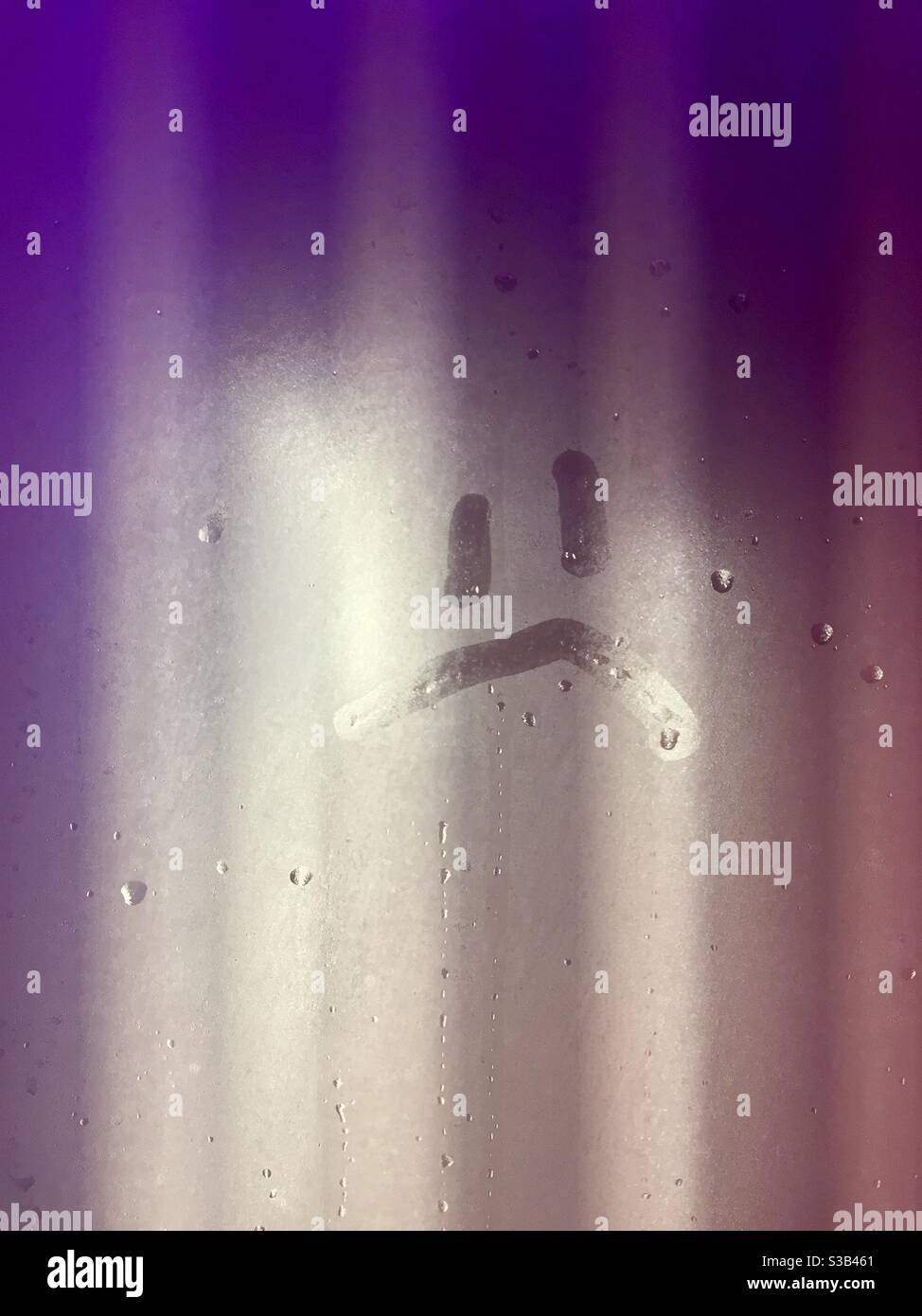 A sad face on a steamy colourful shower window Stock Photo - Alamy