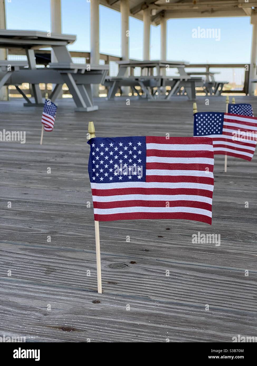 American flags standing on outdoor wooden surface Stock Photo - Alamy