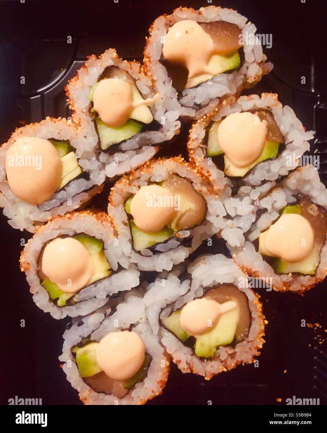 Plate of Sushi containing fermented rice, raw salmon, avocado and spicy ...