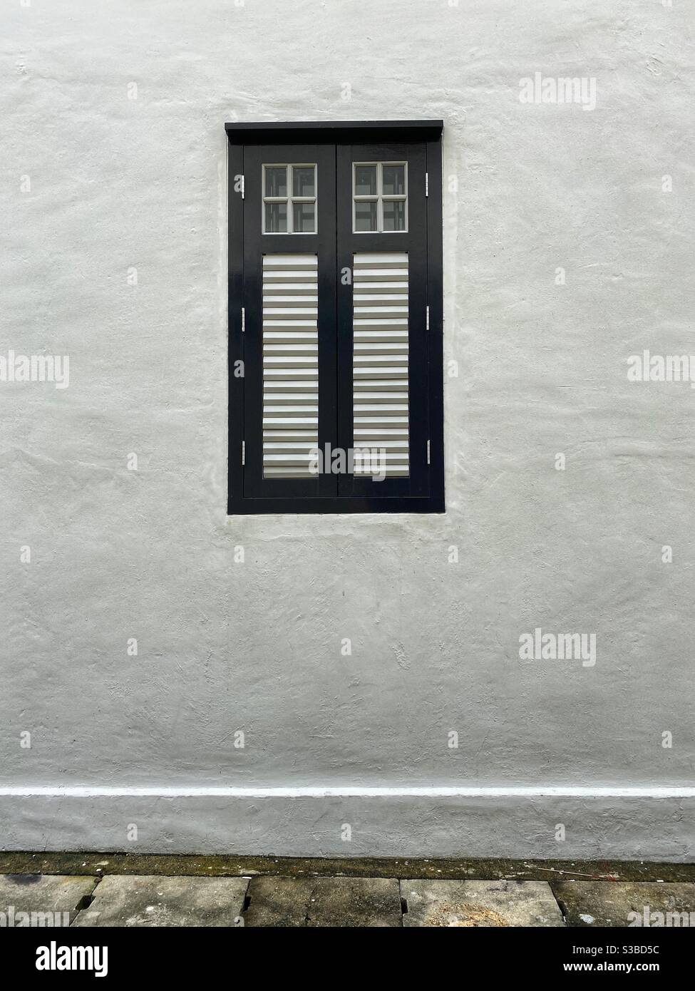 Lonely black and white louvre window along back alley at Chinatown ...