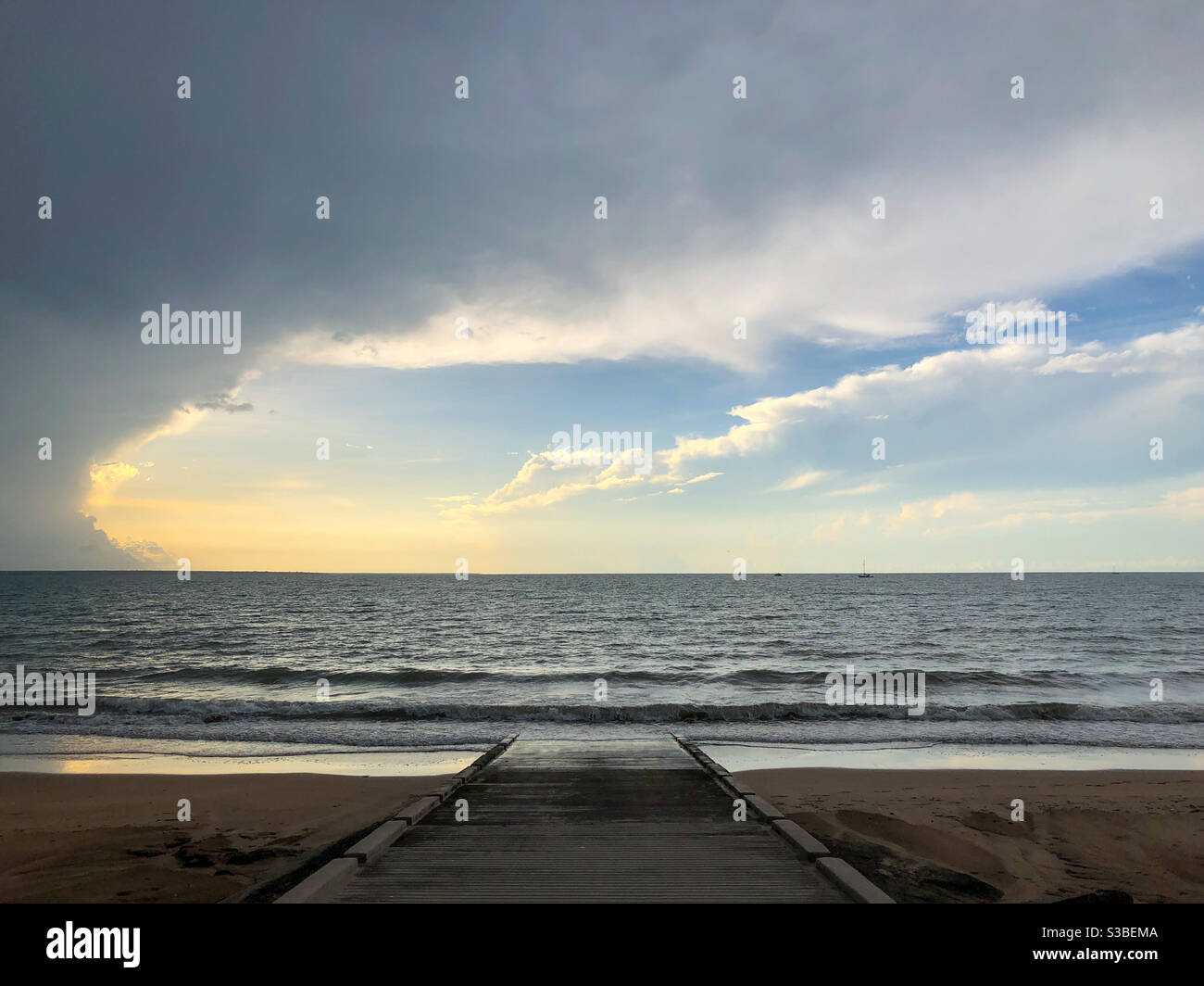 Boat ramp going into the ocean with storm incoming Stock Photo - Alamy