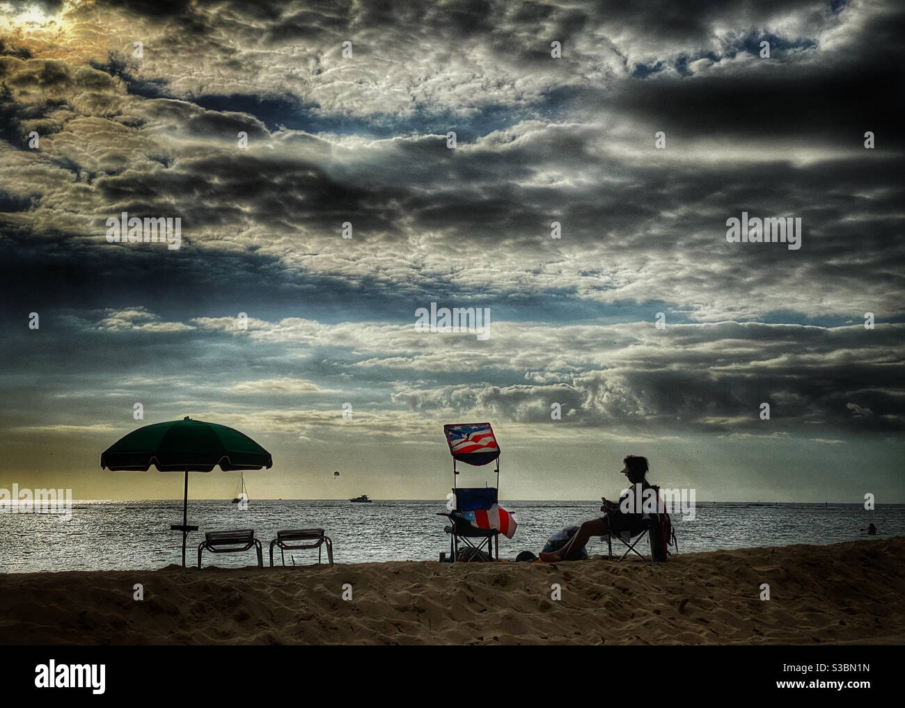 Social distancing, reading alone on the beach Stock Photo - Alamy