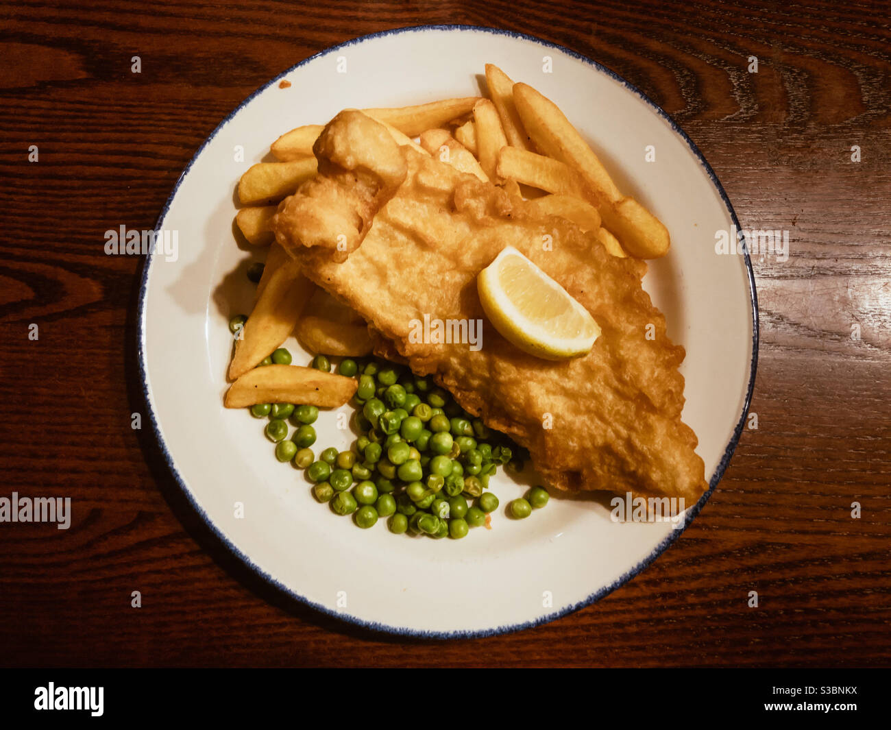 Fish, chips and peas in a restaurant Stock Photo - Alamy