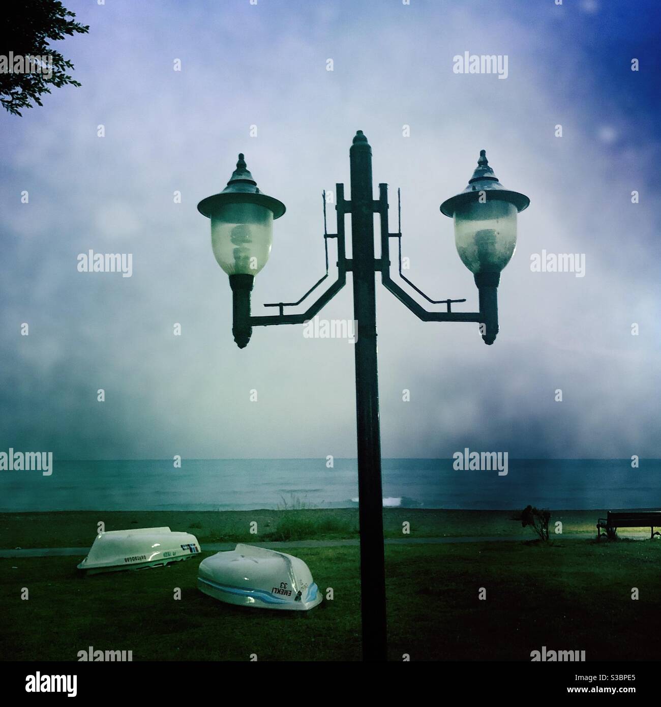 Lamp post and fishing boats by the sea Stock Photo - Alamy