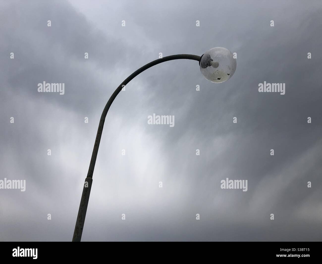 Lonely lamp post against overcast grey cloudy sky Stock Photo - Alamy