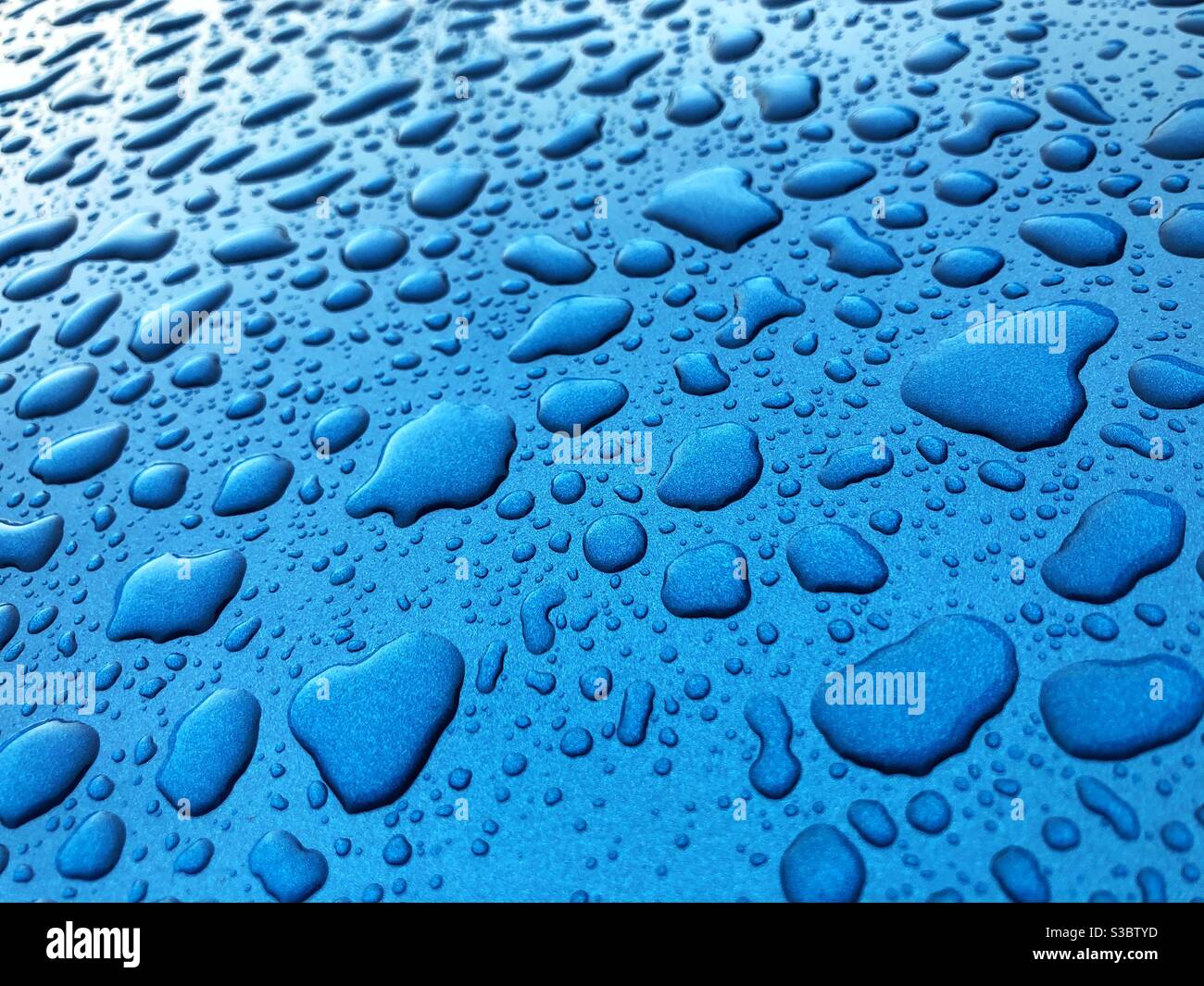 Beaded water on blue metallic metal surface Stock Photo - Alamy