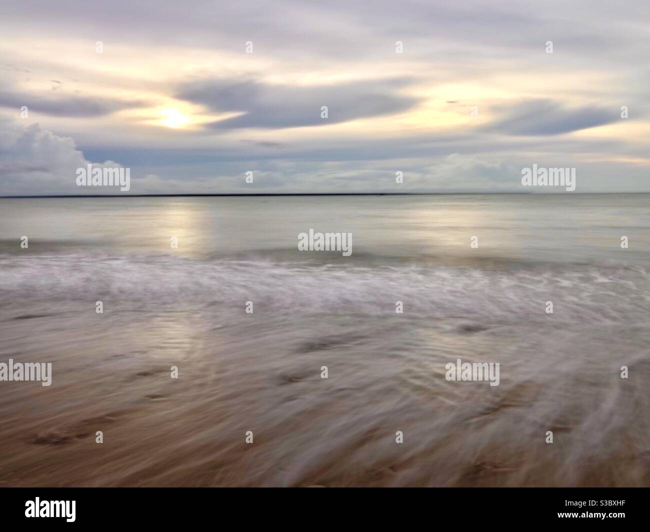 Ocean at the beach with overcast sky Stock Photo - Alamy