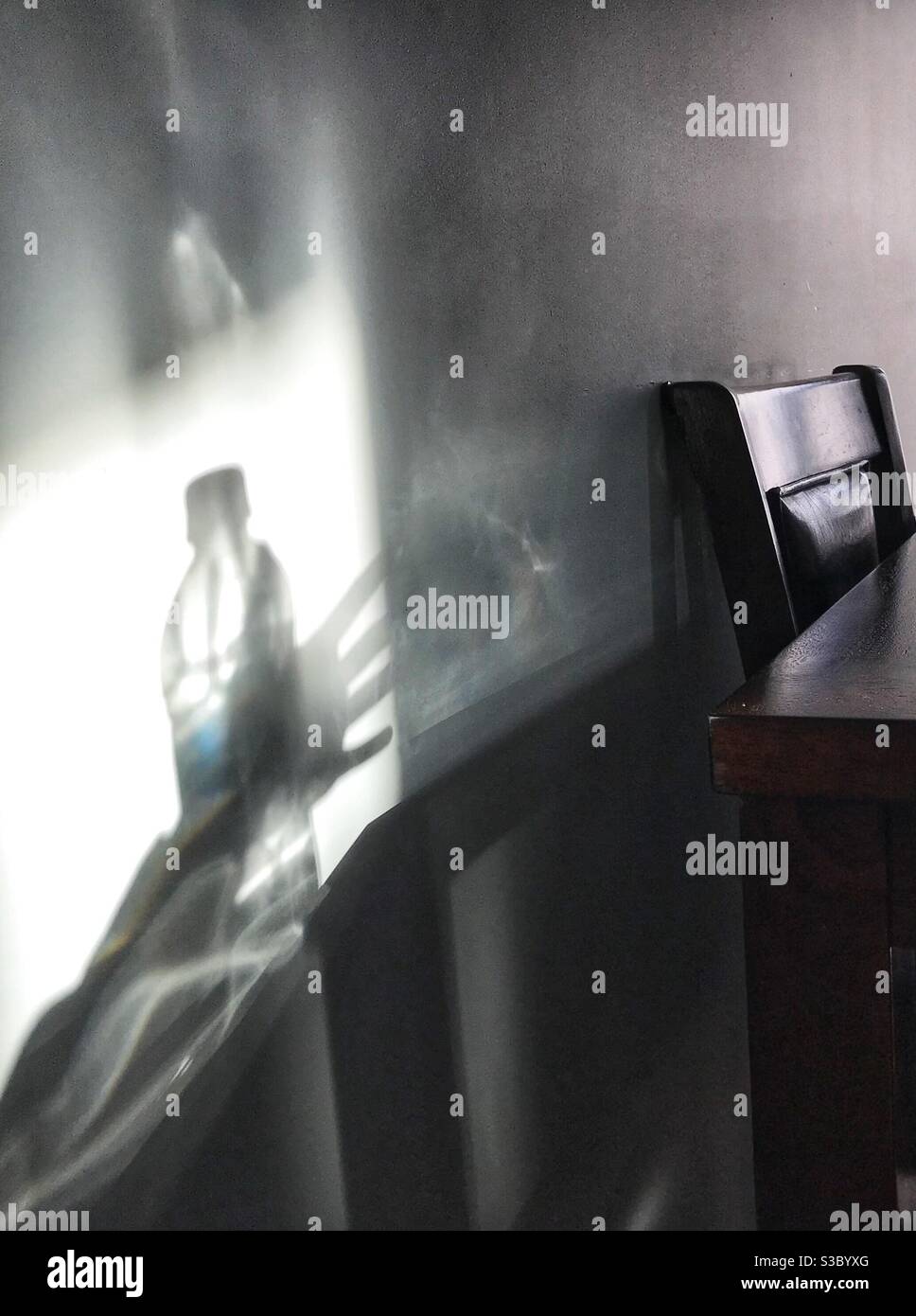 Shadow of a hand stretching towards a water bottle Stock Photo - Alamy