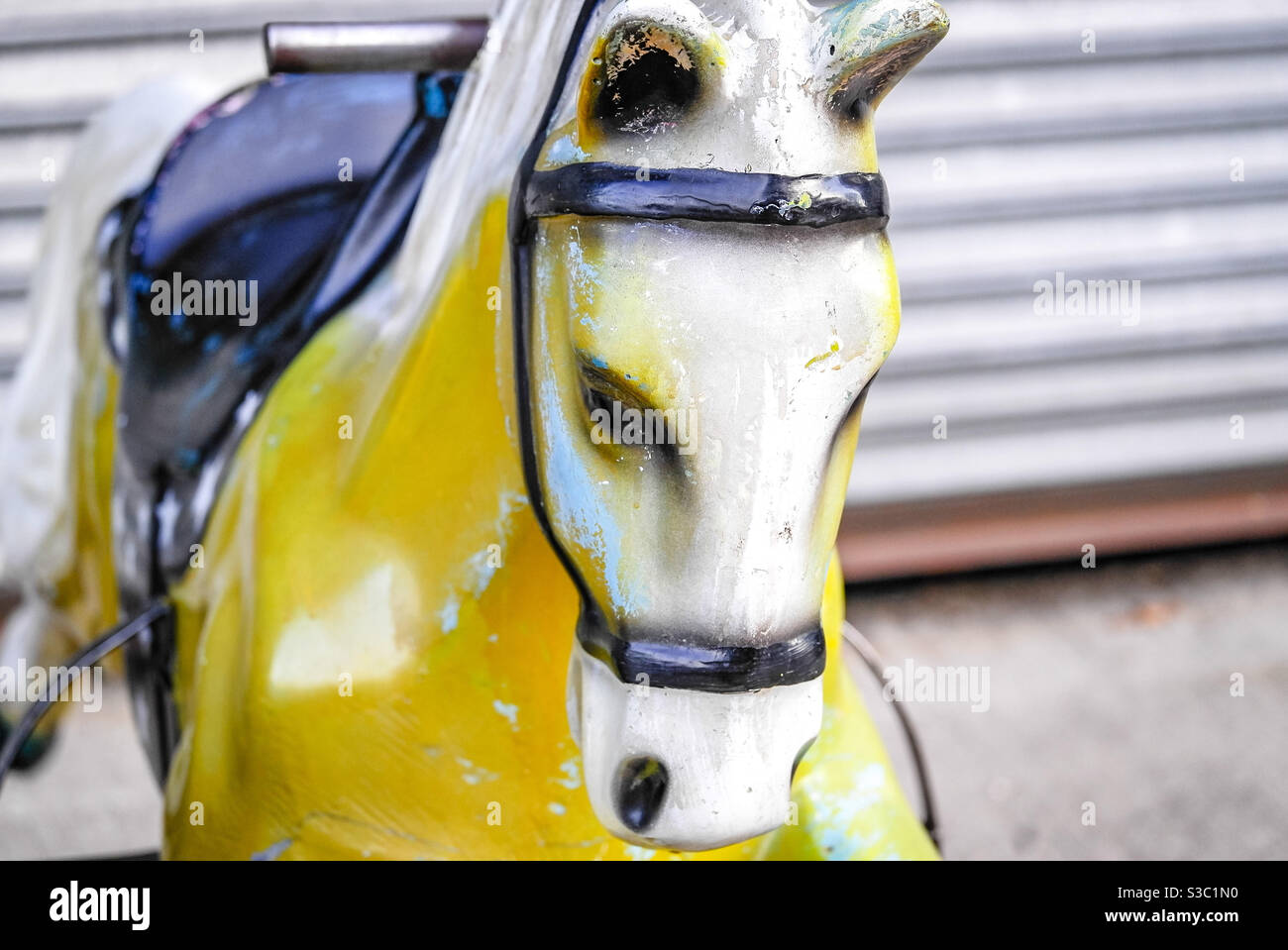 Yellow coin operated horse ride Stock Photo - Alamy