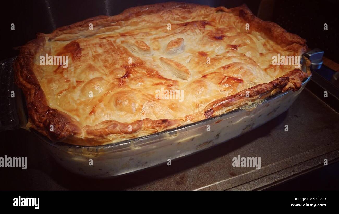 A photograph of a homemade pie with pastry topping, in a glass dish on ...