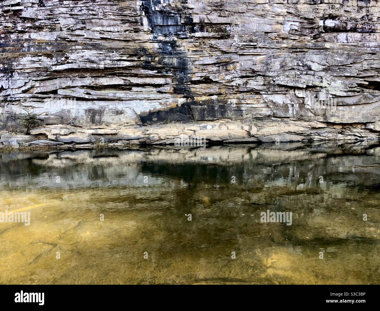 Sedimentary rock on sheer cliff by river Stock Photo - Alamy