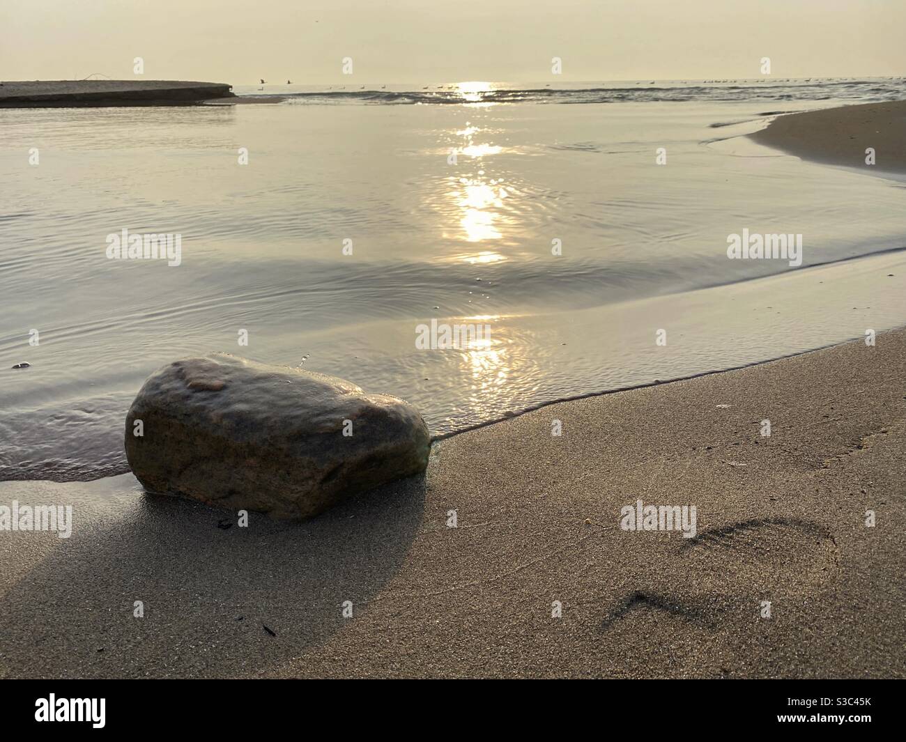 Calm lake in the sunshine, footprint in the sand Stock Photo - Alamy