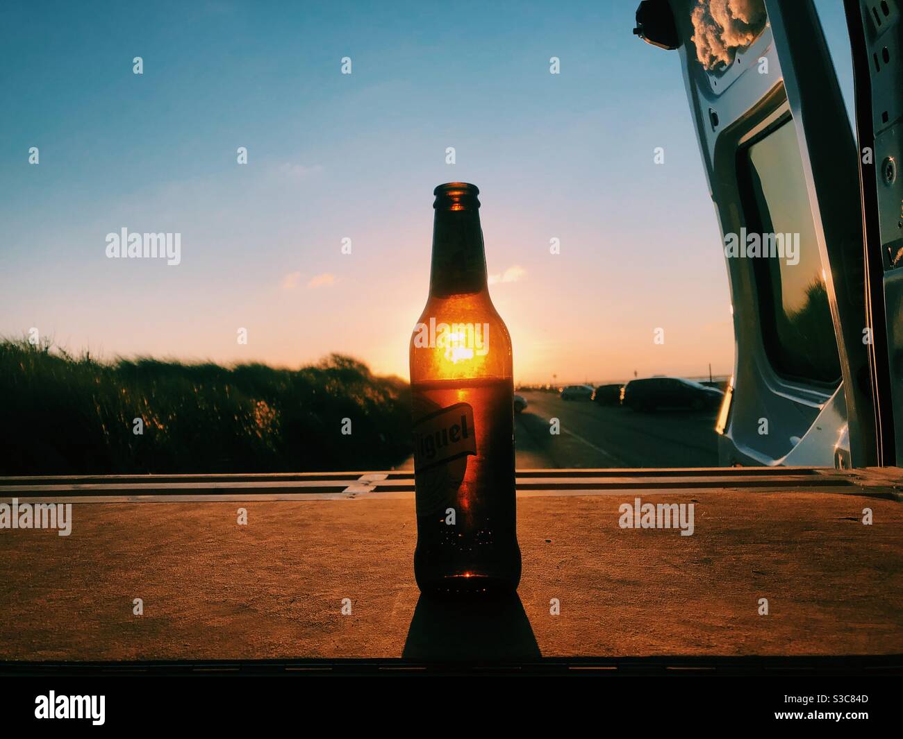 Bottle of beer in front of sunset in back of a camper van Stock Photo ...
