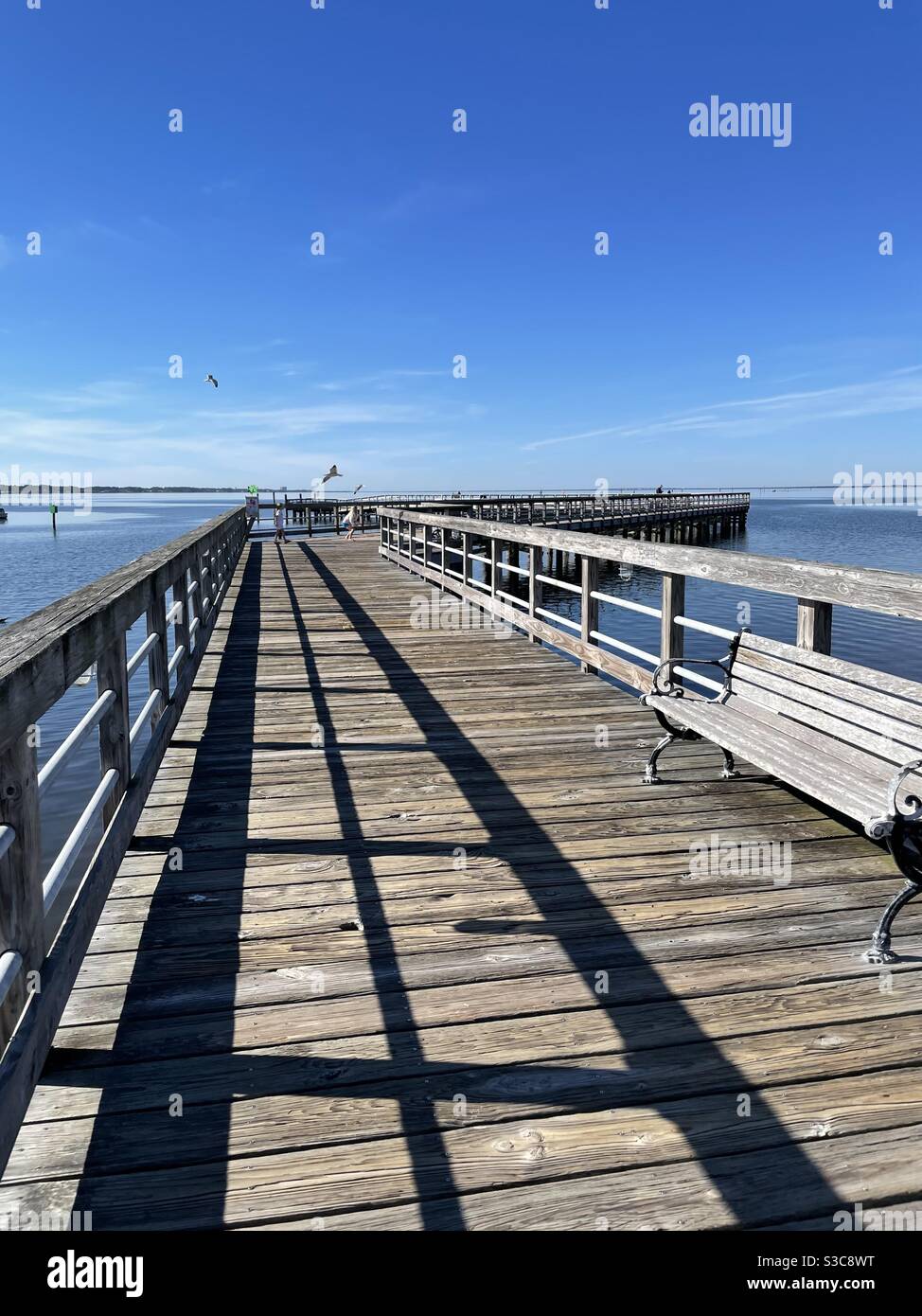 Lines and shadows on a long wooden pier over the Choctawhatchee bay ...