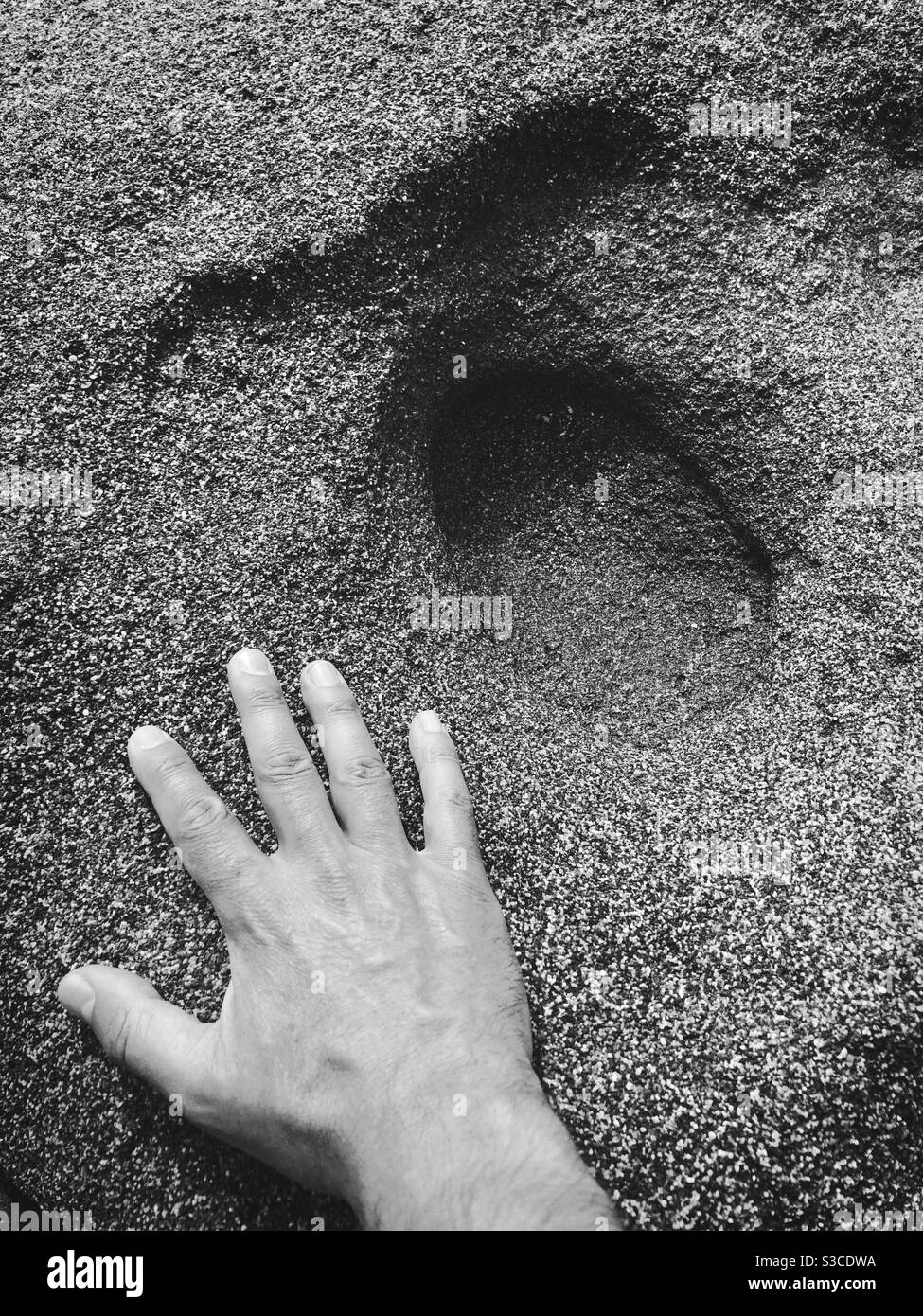 Monochrome image of a Hand touching a textured rock Stock Photo - Alamy