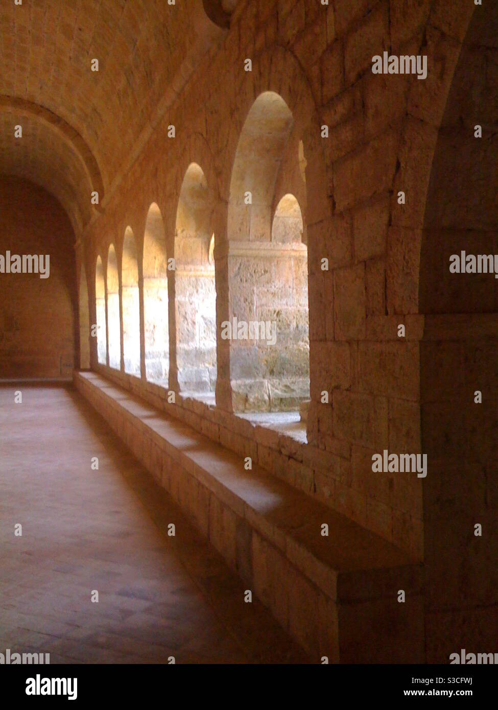 Pretty French monastery corridor with curved arches supported by old ...