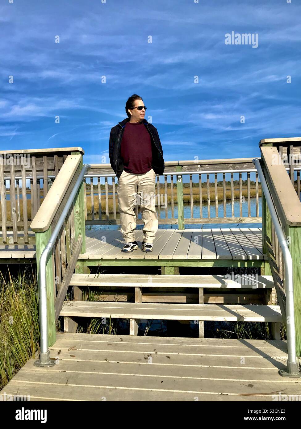 Man standing on boardwalk Stock Photo - Alamy