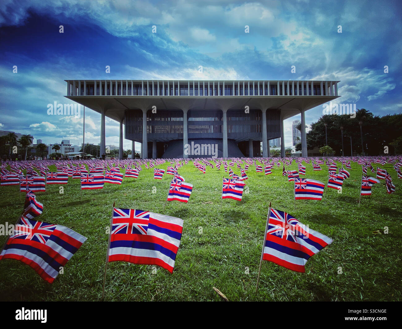 Hawaii state capital building seen across a field of Hawaii state flags ...